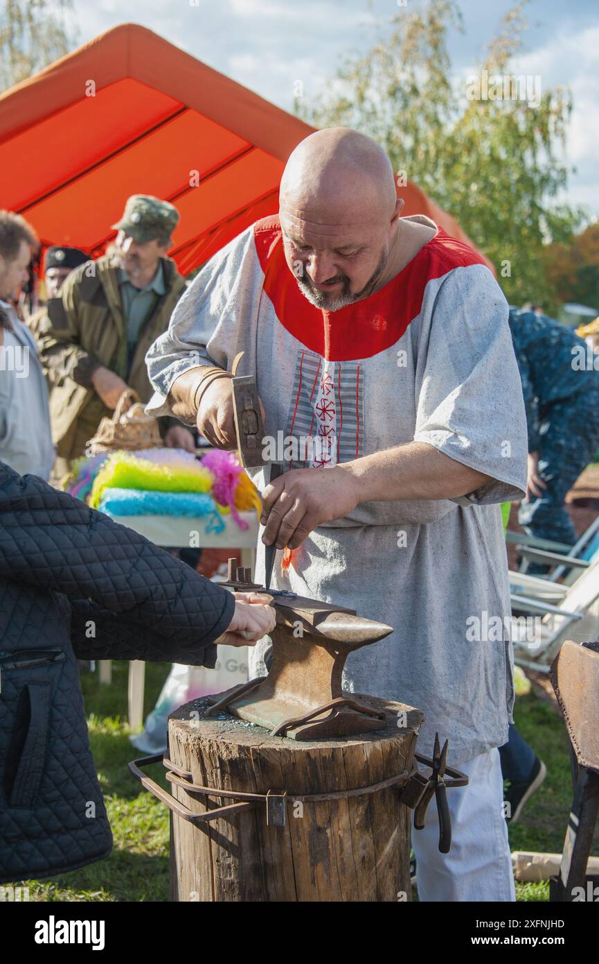 Moscow, Russia October 1, 2016: A blacksmith forges a horseshoe for a ...