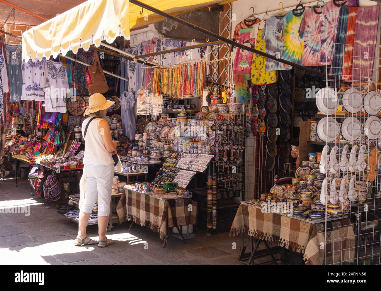 Mexico market; Woman tourist shopping at a colorful stall in the ...