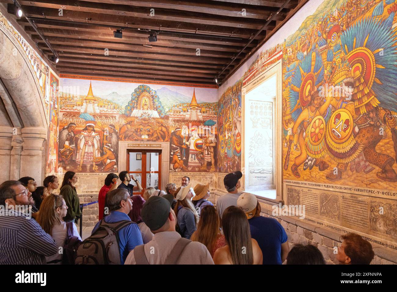Tourists looking at the colorful historic murals by Desiderio Hernández ...