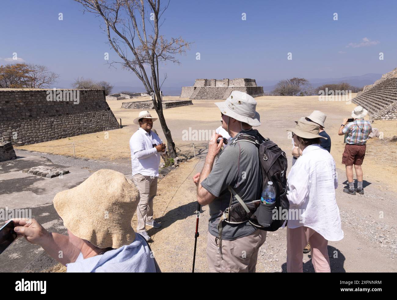People on a guided tour with tour guide at Xochicalco mayan ruins, as ...