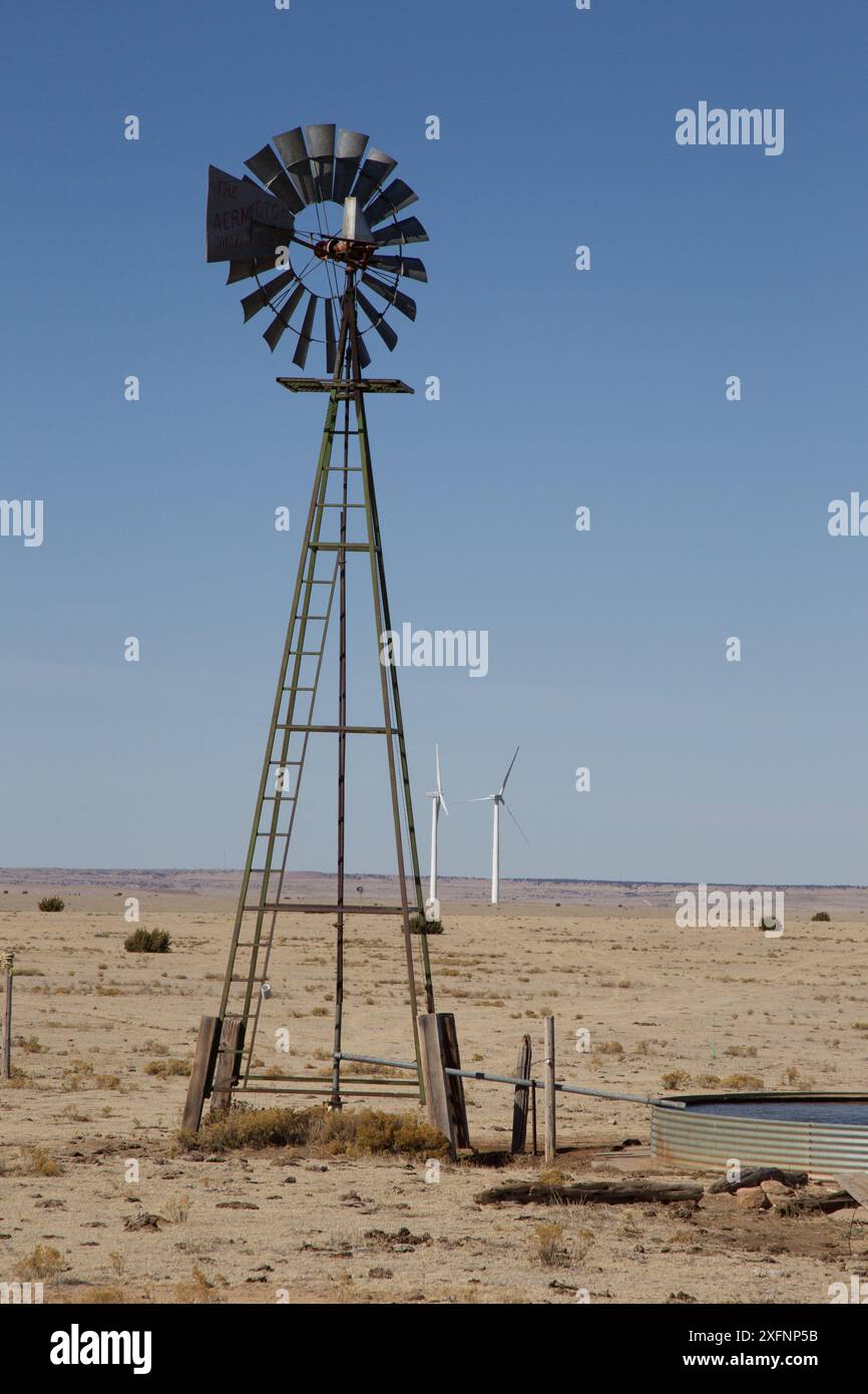 Old an new. Water pump wind mill in foreground. Wind turbines in wind ...