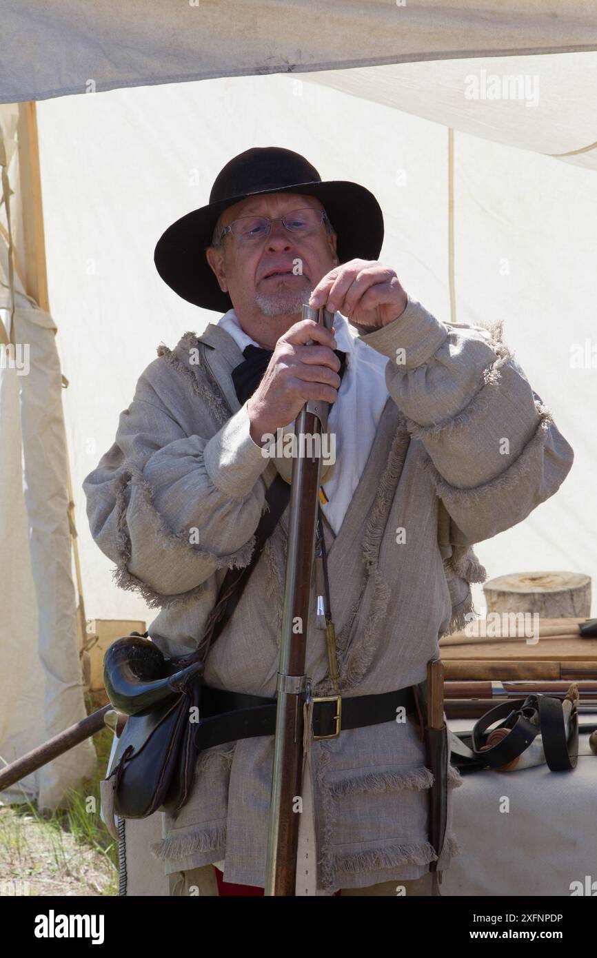 Reenactor explains the process of loading a musket (firearm carried by ...