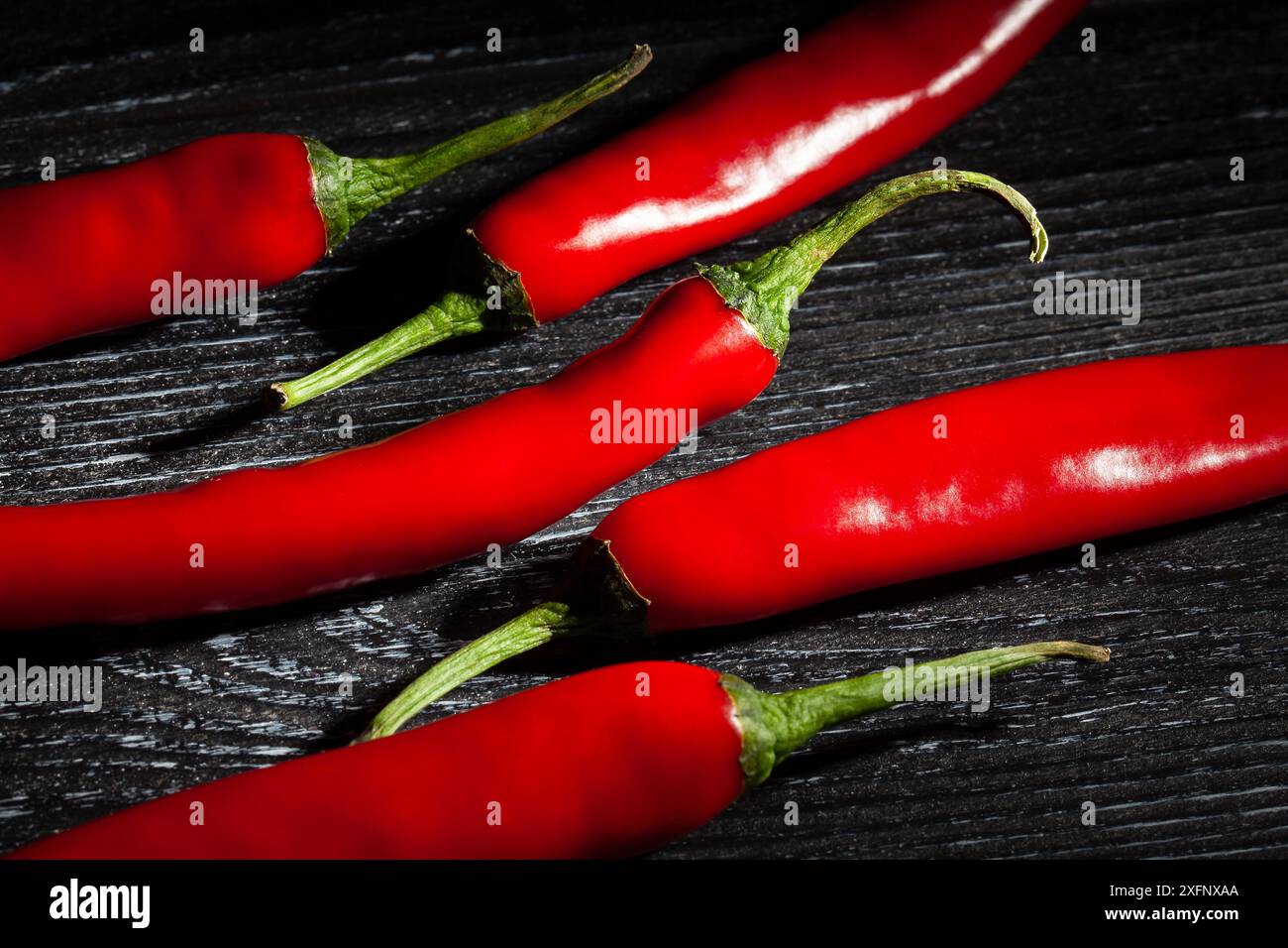 long chili pepper on black wood background Stock Photo - Alamy
