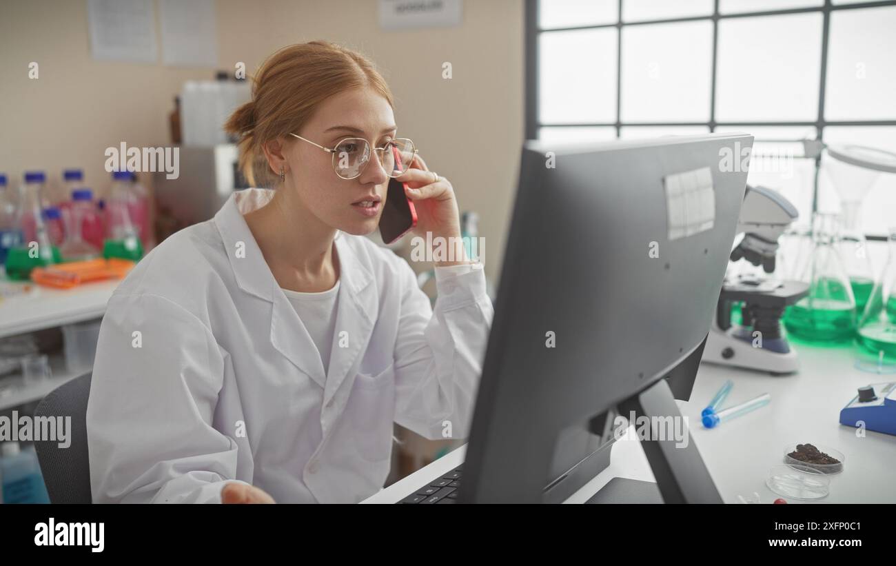 Focused caucasian woman scientist using computer and phone in a ...