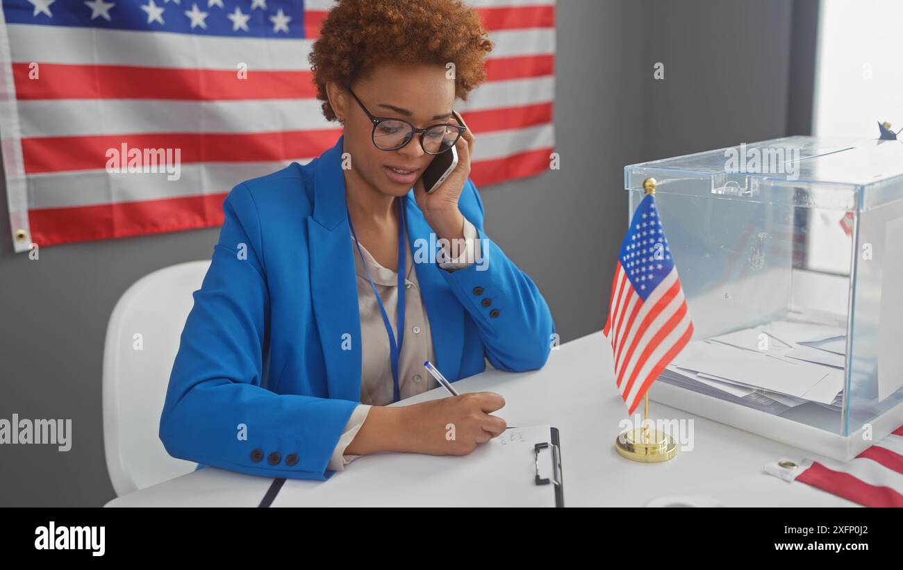American woman in blue jacket taking notes on a phone call in front of ...