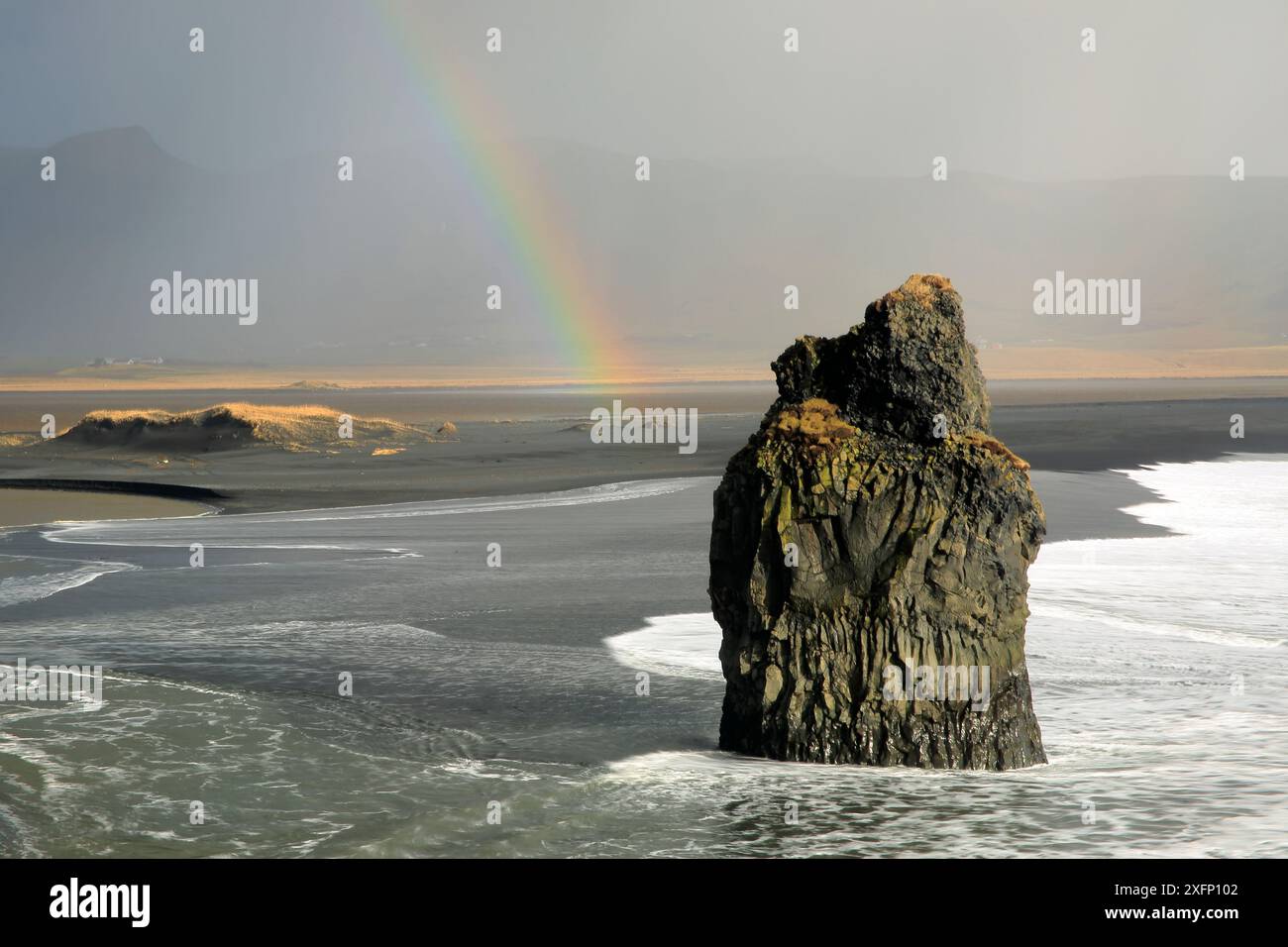 Reynisdrangar basalt sea stack with rainbow, Vik, Iceland, February ...