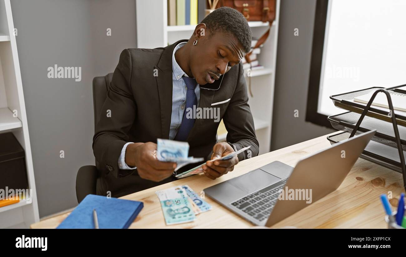 Black man counting chinese yuan in an office while talking on a ...