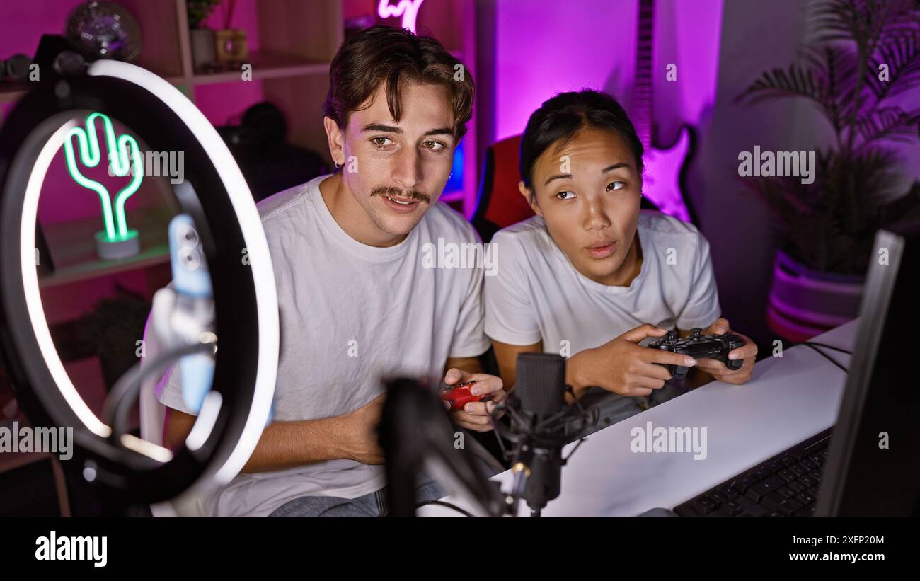 Interracial couple gaming together in a dark room with neon lights and ...