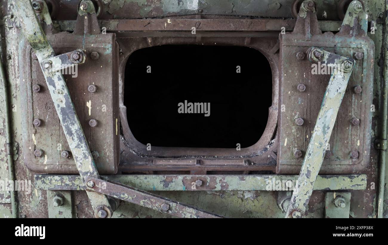 Broken locomotive firebox door. A close-up fragment of the open firebox ...