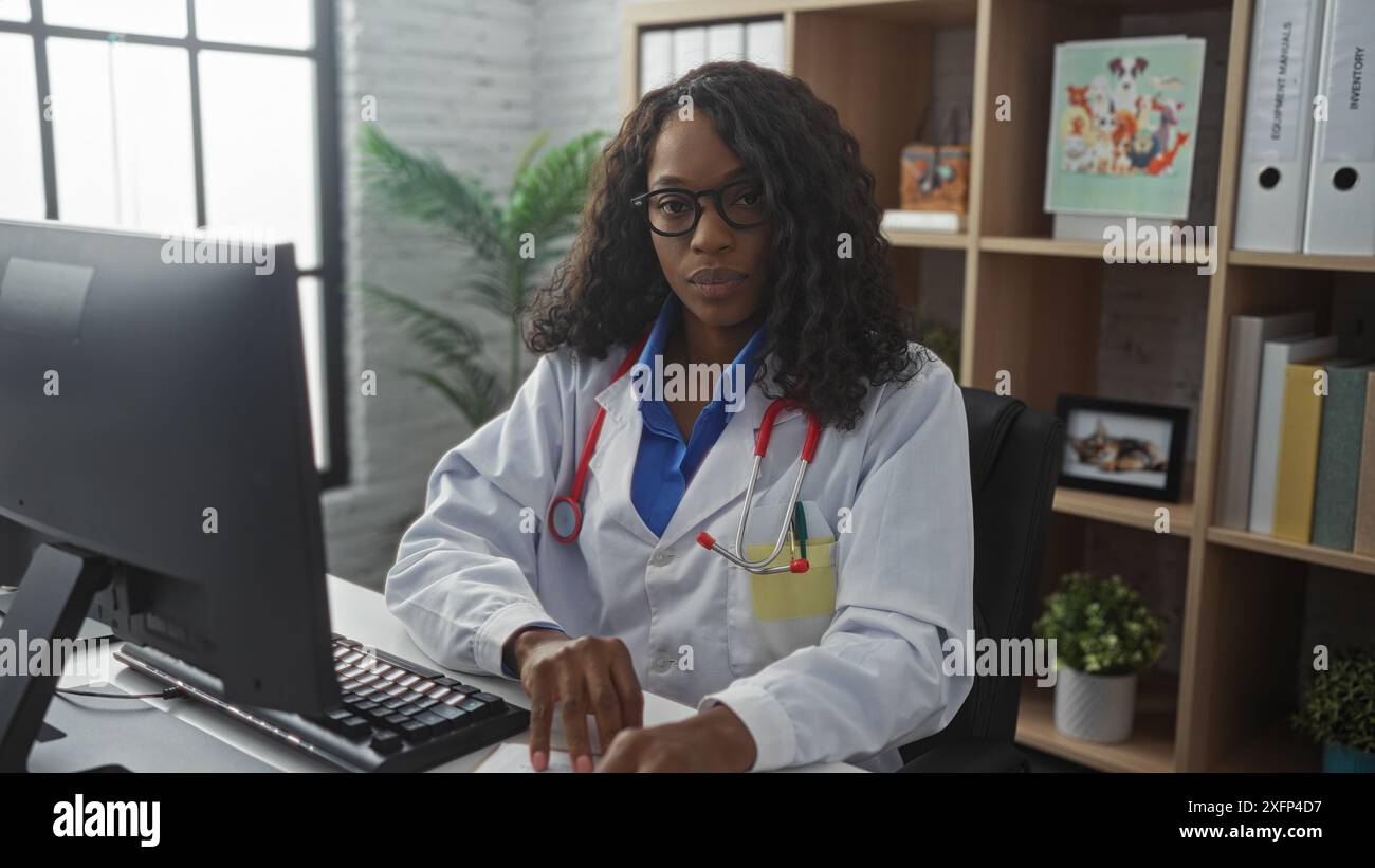 An african american female doctor with curly hair works at a computer ...