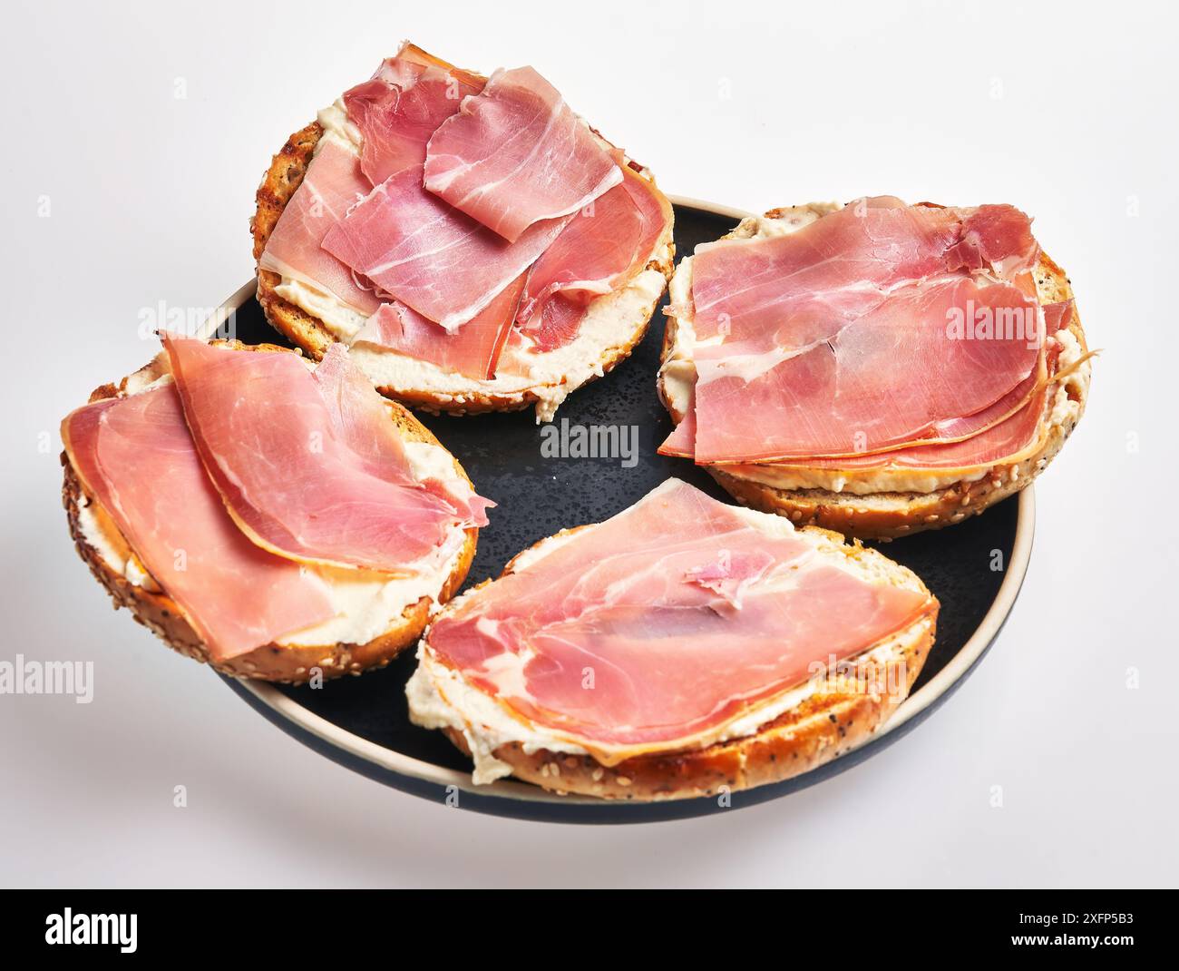 A plate of freshly prepared open-faced sandwiches with prosciutto and ...