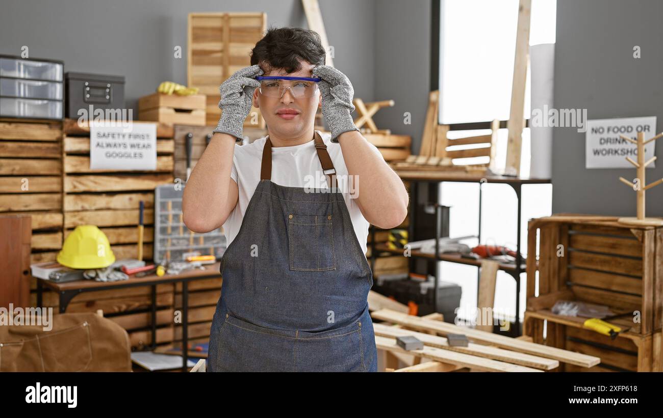 A young man adjusts safety goggles in a well-organized carpentry ...