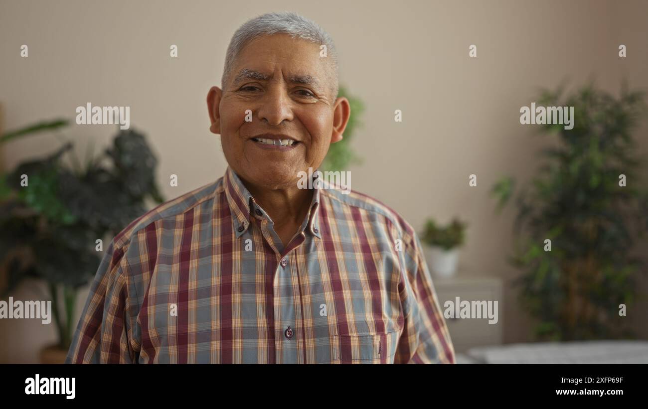 Elderly hispanic man with grey hair smiling indoors in a cozy living ...