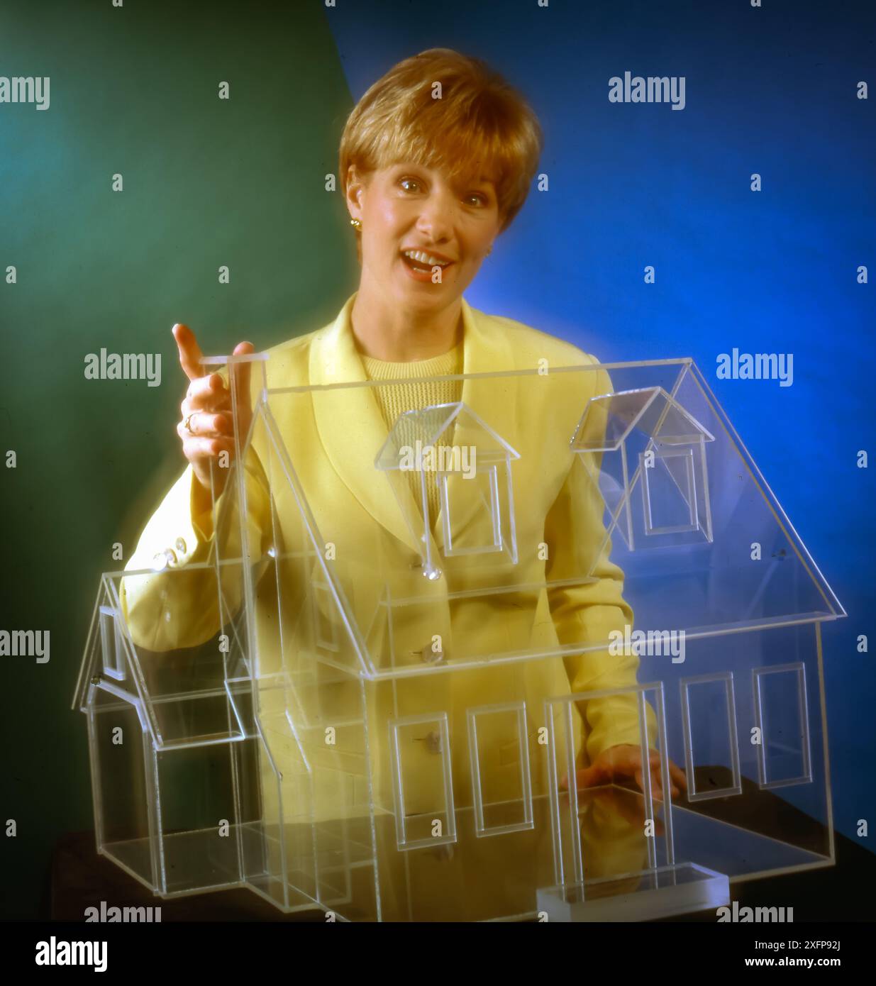 Young female real estate agent, home owner with transparent glass house ...