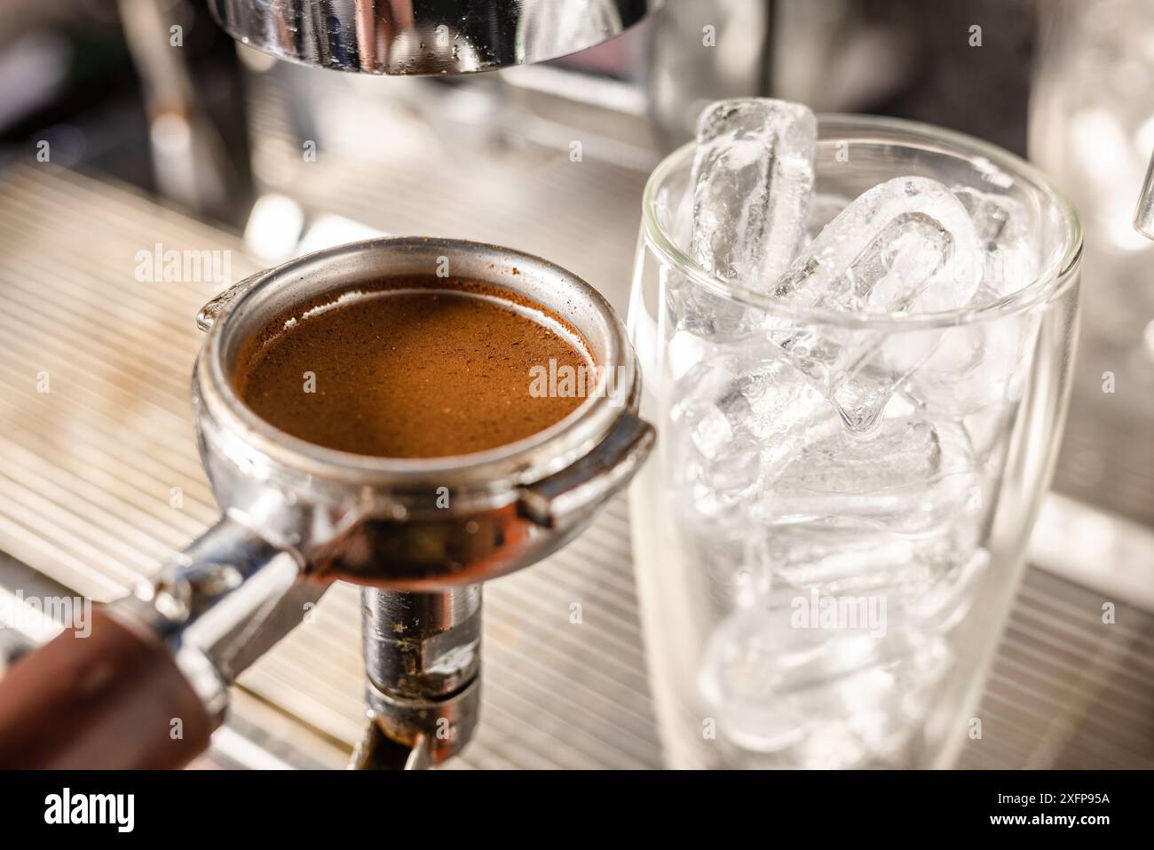 the barista's hand holds a cone with ground coffee near the coffee ...