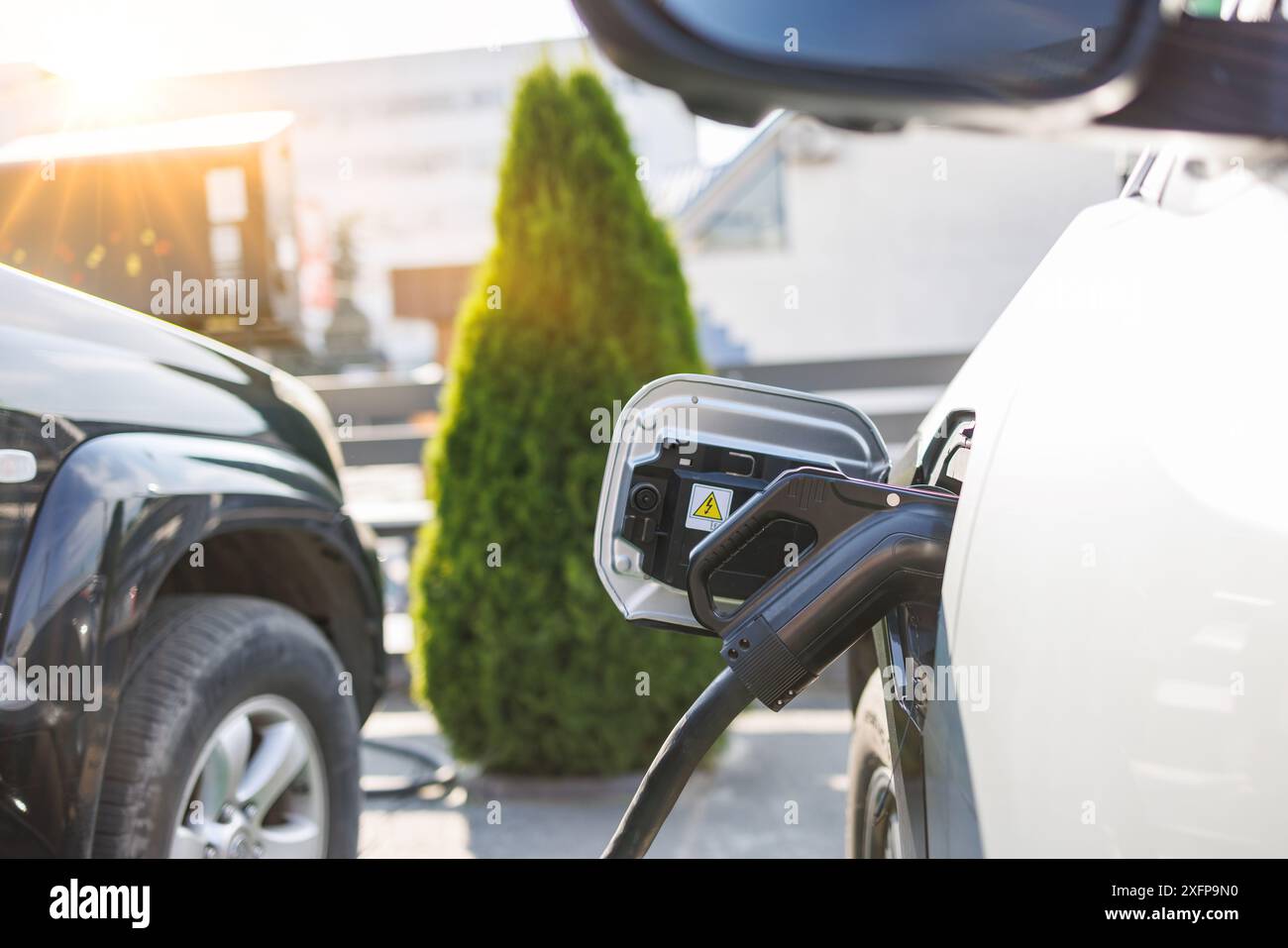 a girl charges her electric car at a charging station, Environmentally ...