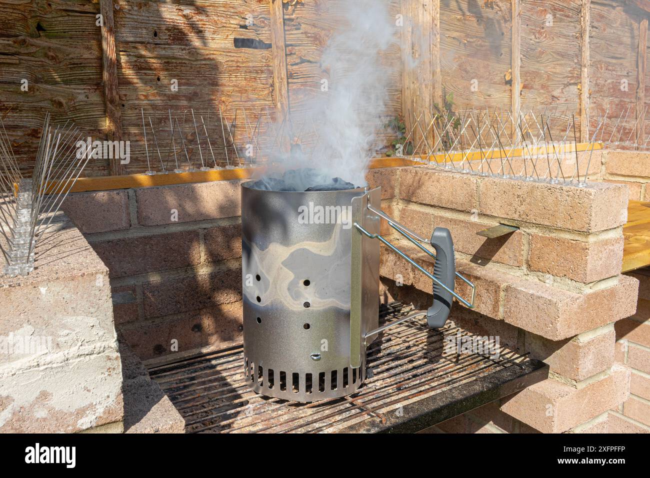 Preparing charcoal and briquettes in a bbq chimney starter - the ...