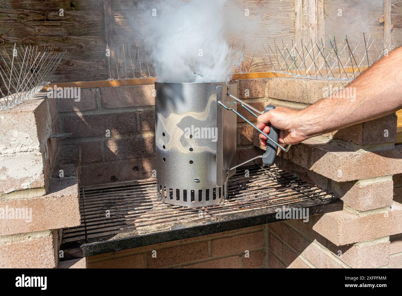 Preparing charcoal and briquettes in a bbq chimney starter - the ...