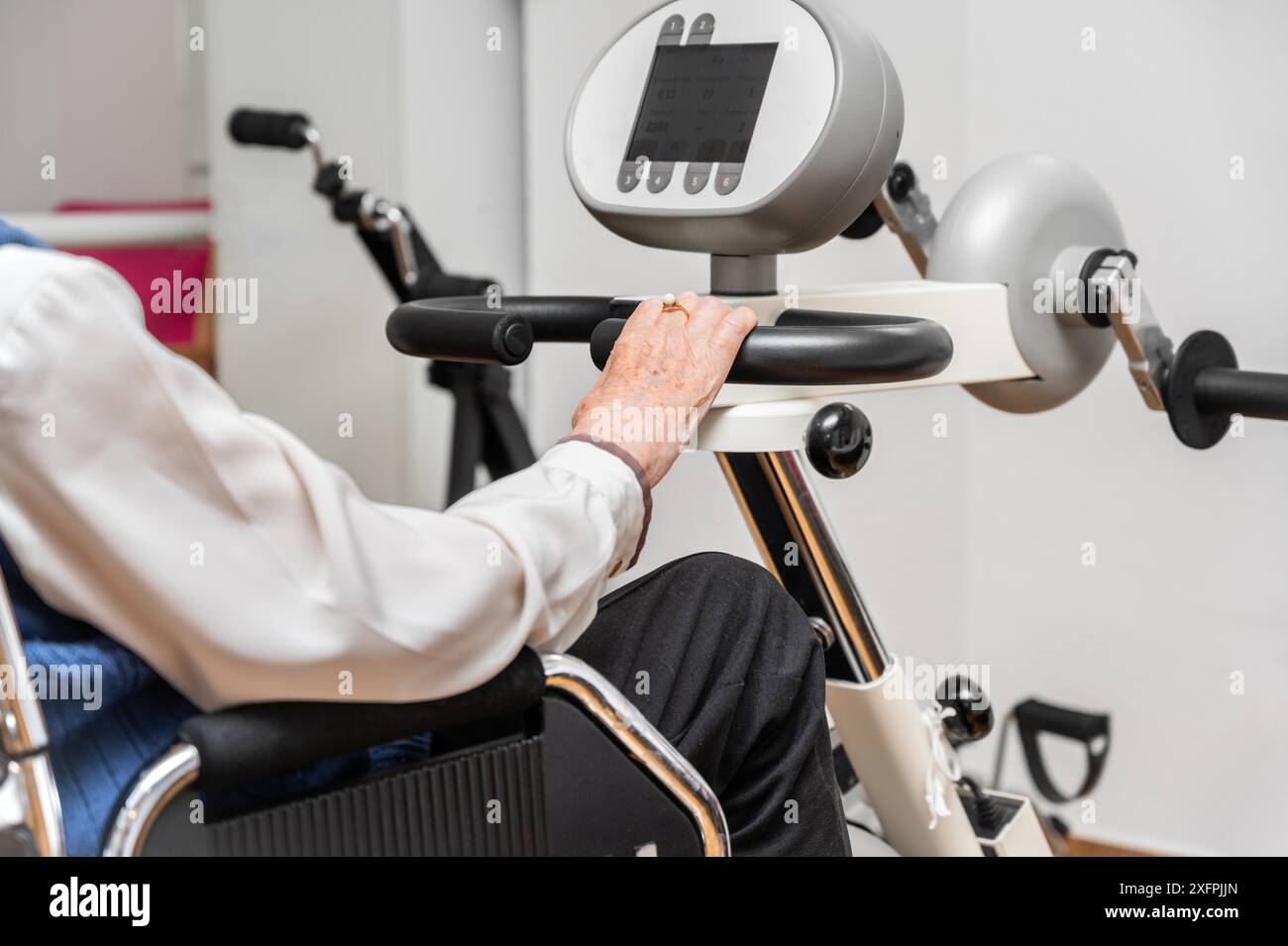An unrecognizable elderly woman does pedal exercises from wheel chair ...
