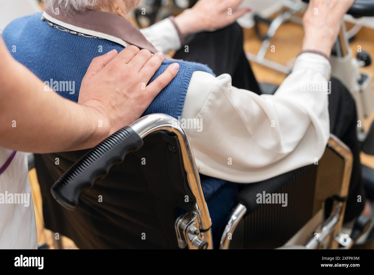 Close up nurse touch shoulder of elderly patient woman in wheelchair ...
