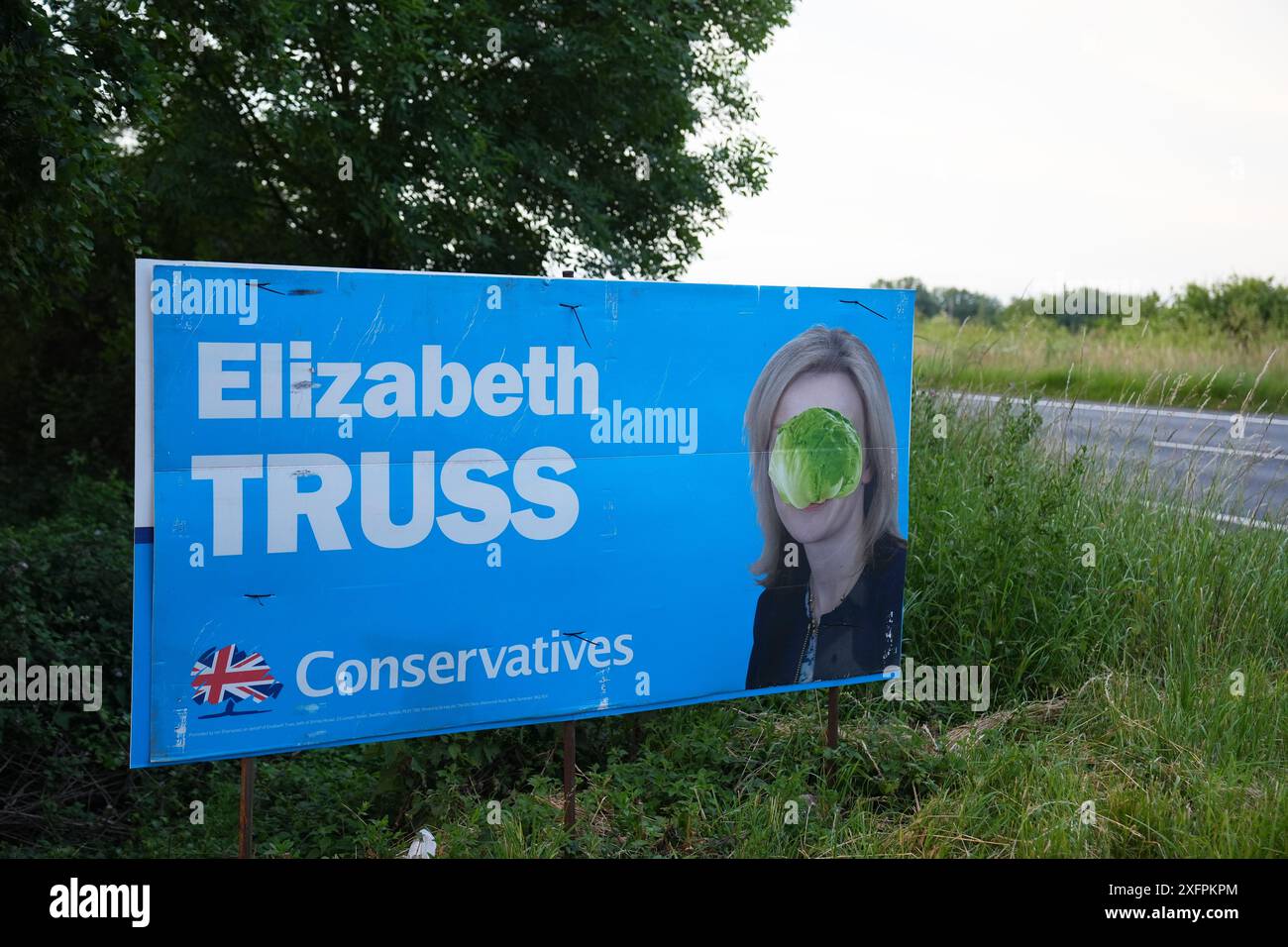 A lettuce covers the face of Liz Truss on a campaign advertising board ...