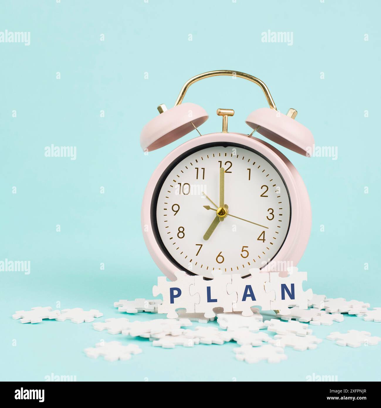 Alarm clock with the word plan standing on puzzle pieces, brainstorming ...