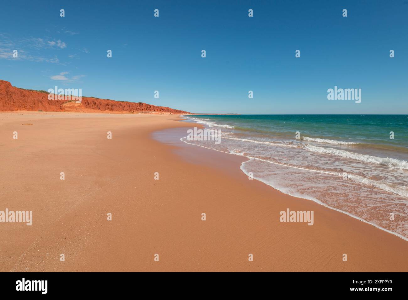 Ochre-coloured earth and sandstone cliffs with white sands beach ...