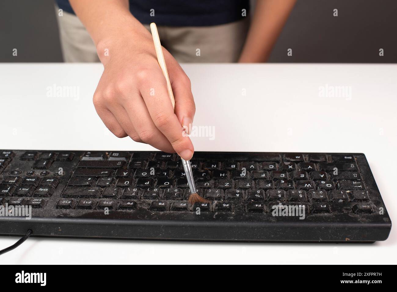 Cleaning computer keyboard in office with rubber protective glove and a ...