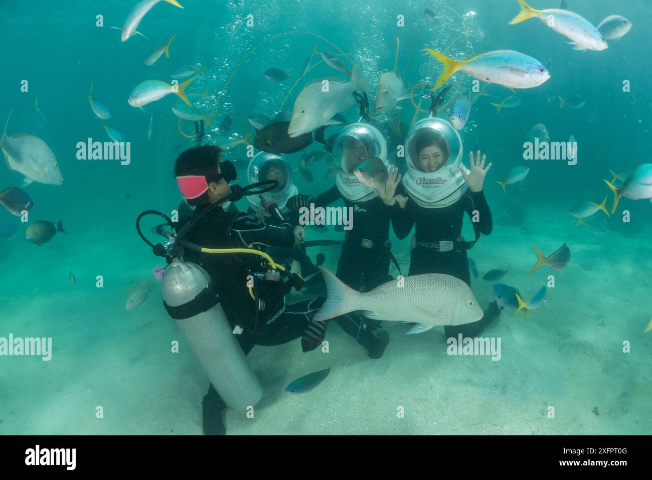 Tourists helmet diving and walking around the shallow reefs of Green ...