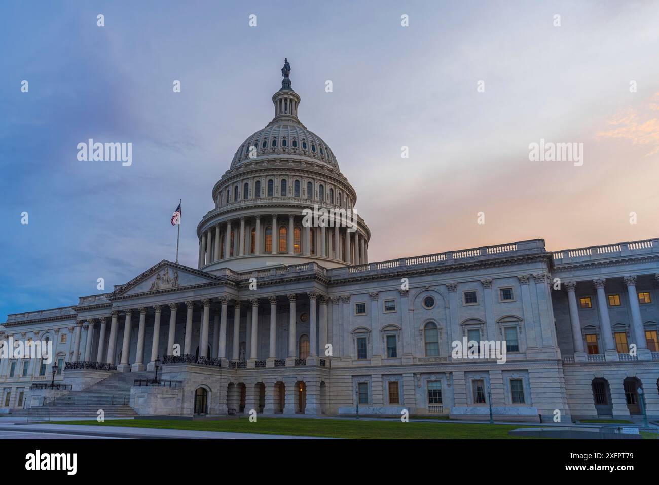 The United States Capitol building at blue hour with American flag ...
