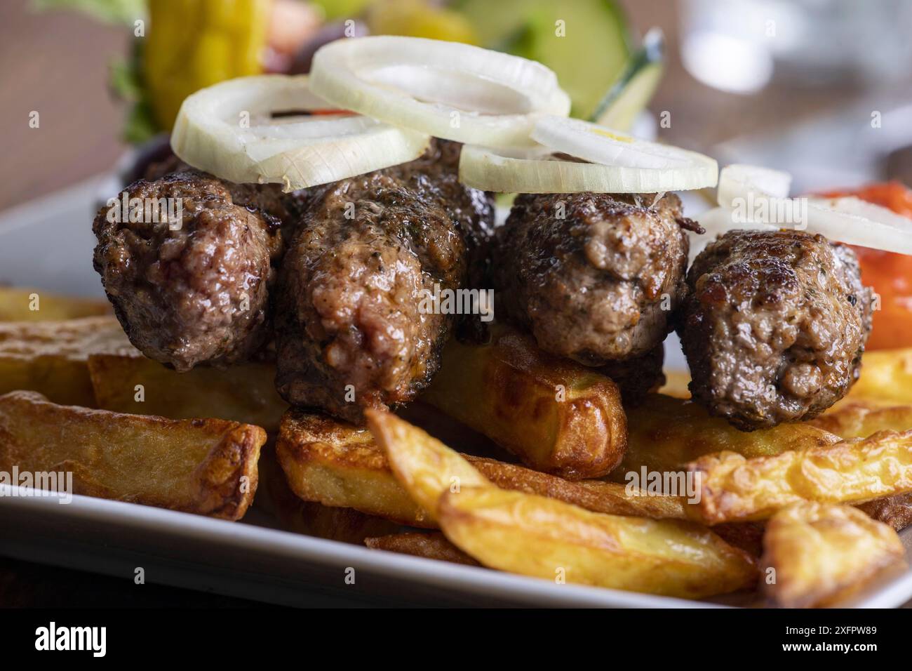 Cevapcici with chips and onion rings Stock Photo - Alamy