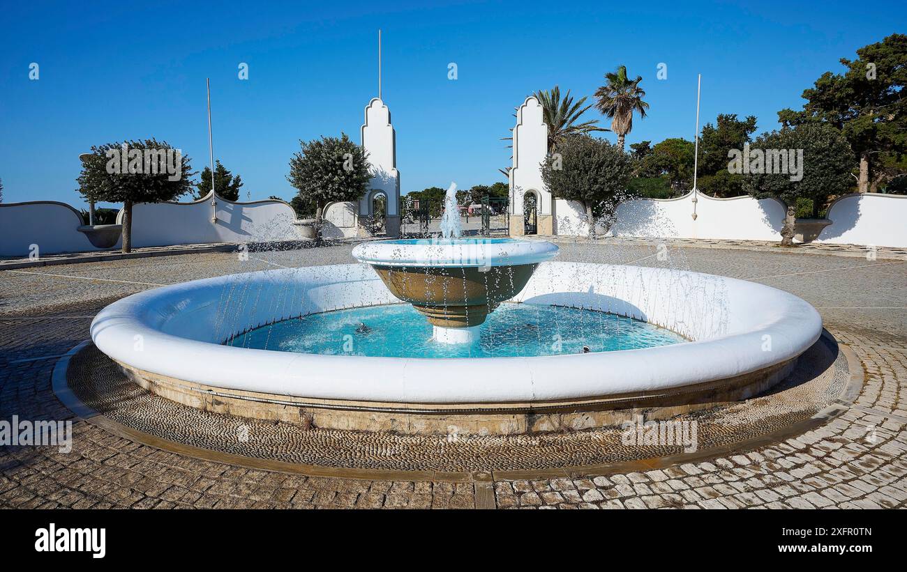 Round fountain with splashing water surrounded by architectural ...