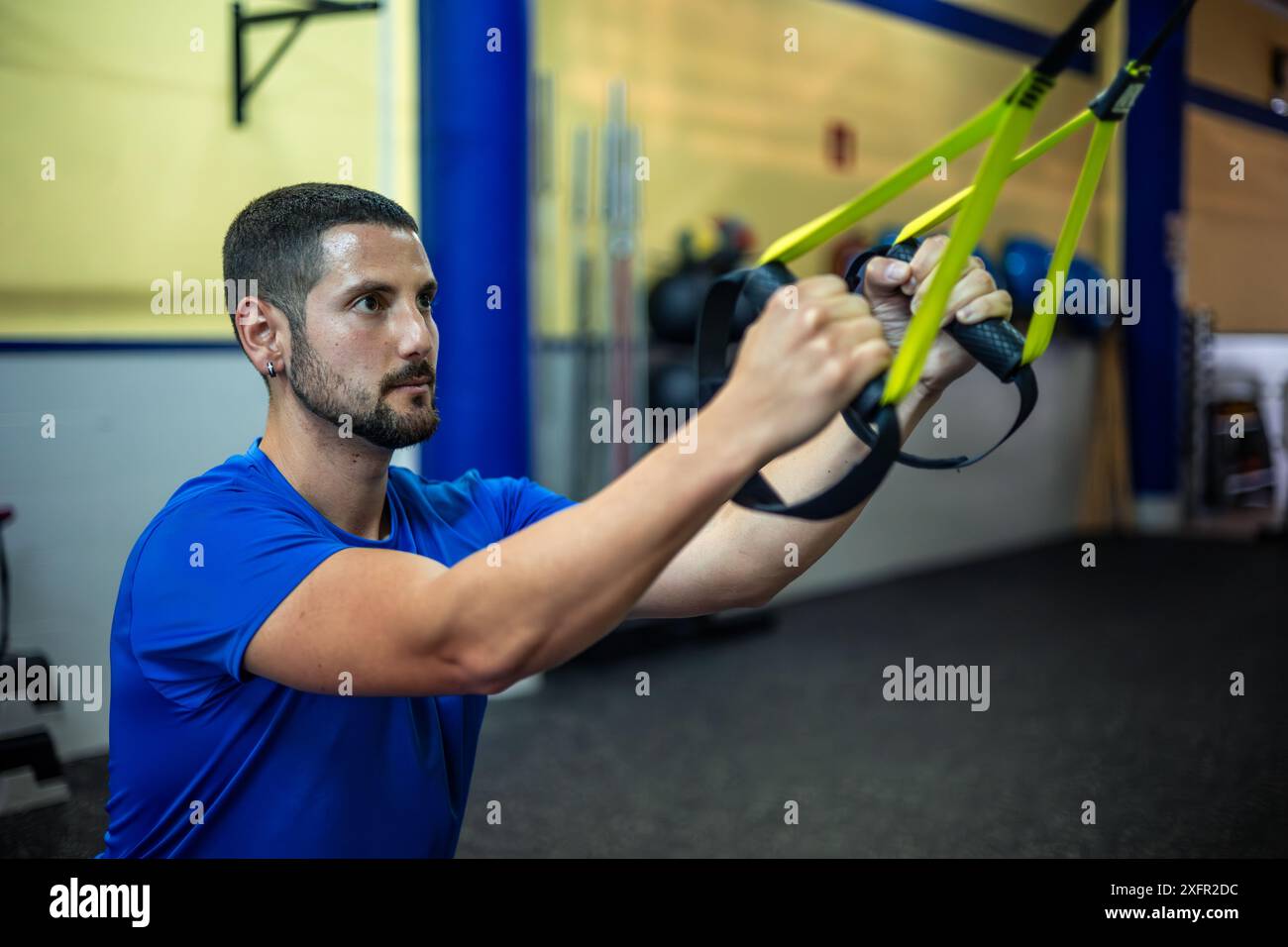 closeup view of a young athlete training his arm muscles using TRX ...