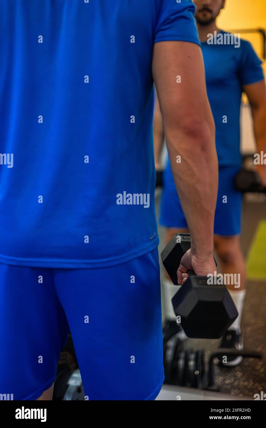 closeup view of a fitness sportsman's arm holding a dumbbell ...