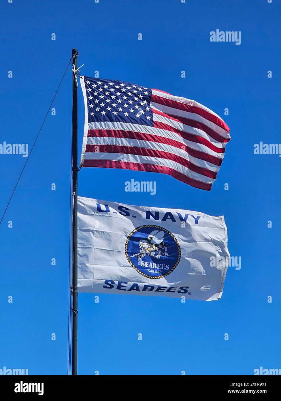 U.S. flag and Seabee flag fly over the Humanitarian Assistance and ...