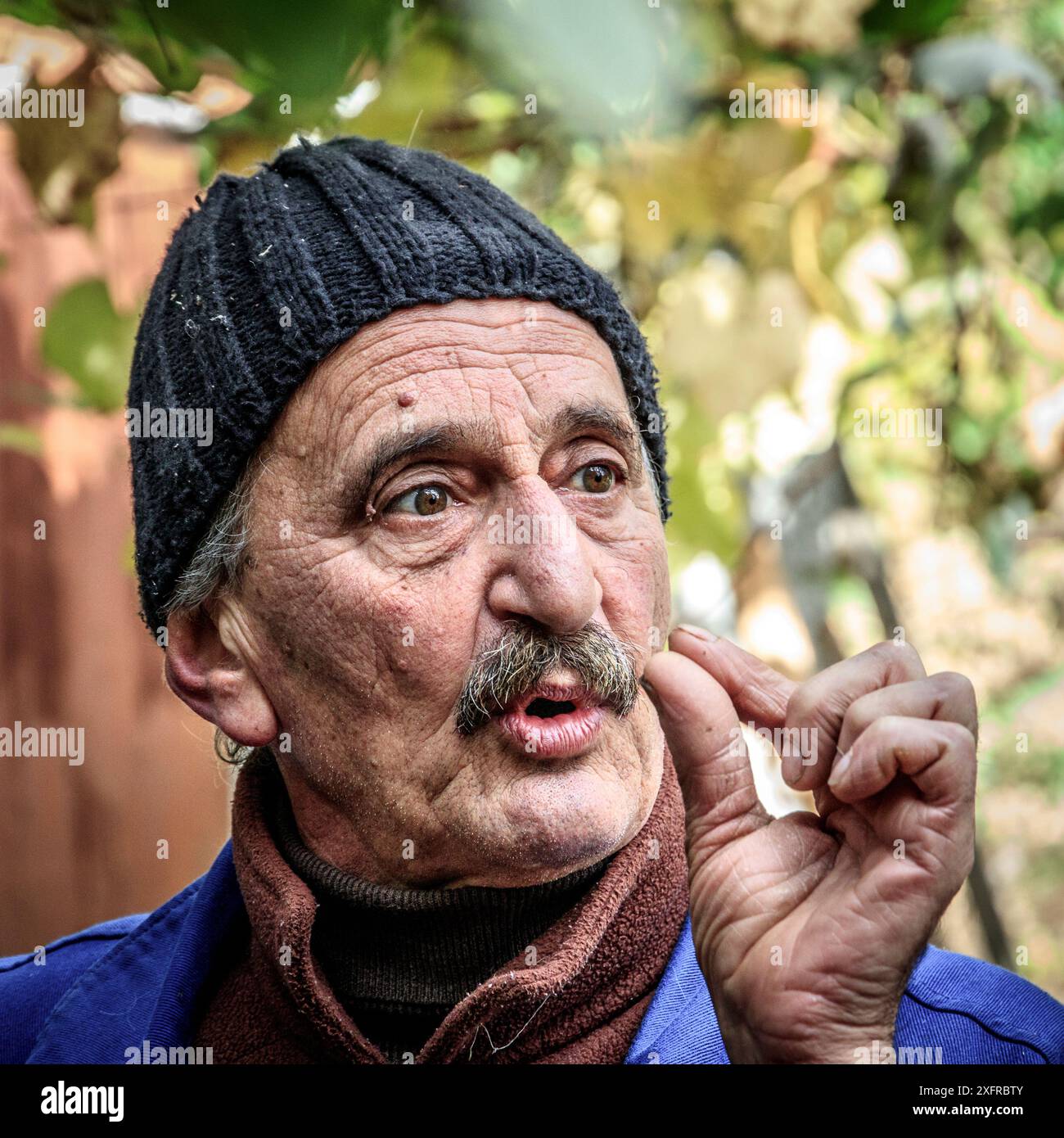 Europe, Romania, Viscri. Local villager explaining how the Grist Mill ...
