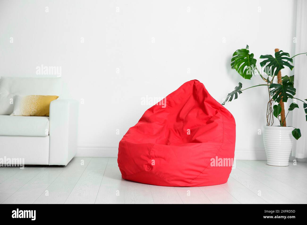 Red bean bag chair on floor in room Stock Photo - Alamy