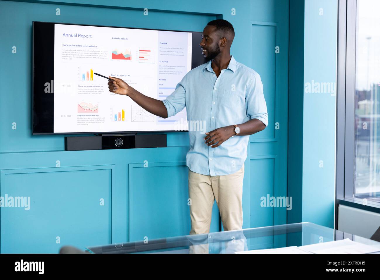 Presenting annual report, man pointing at screen with graphs in modern ...