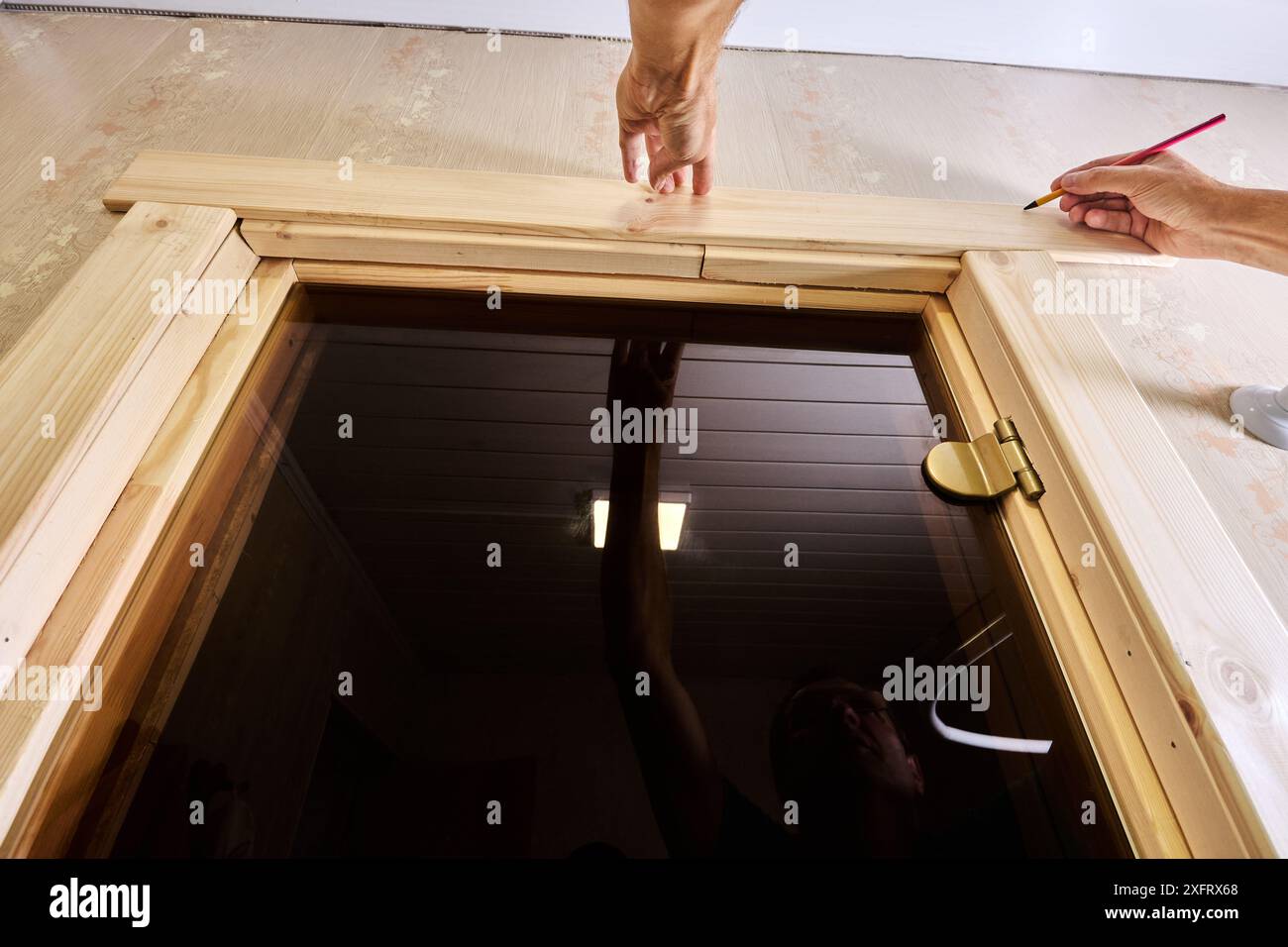 Creating marking door frame using pencil and piece of trim Stock Photo ...