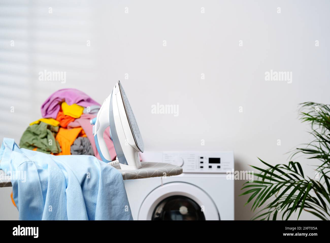 Modern Laundry Room With White Washing Machines, Ironing Board, and ...