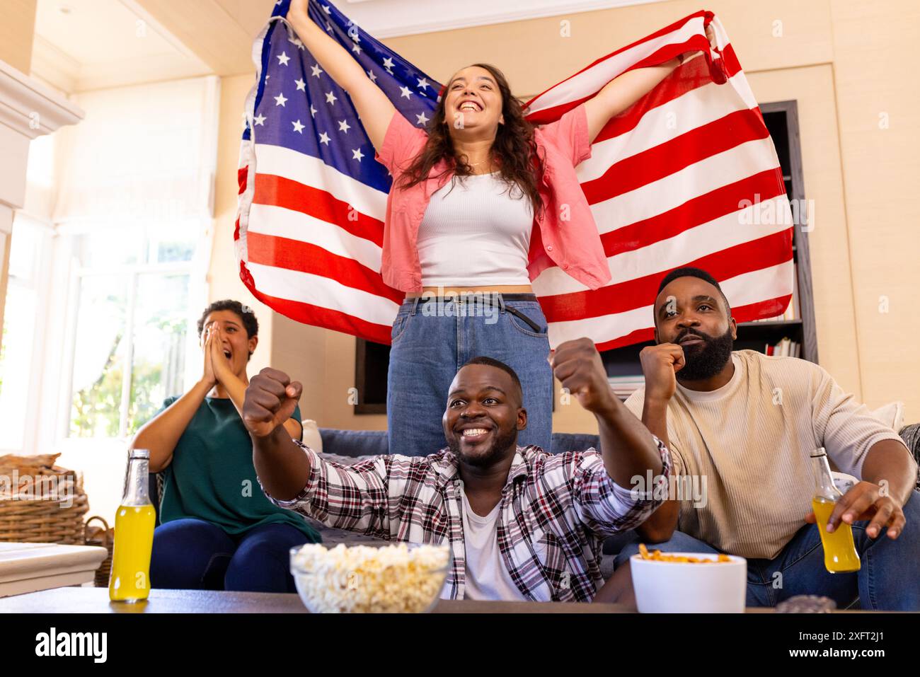 Celebrating with diverse friends, woman holding American flag while ...