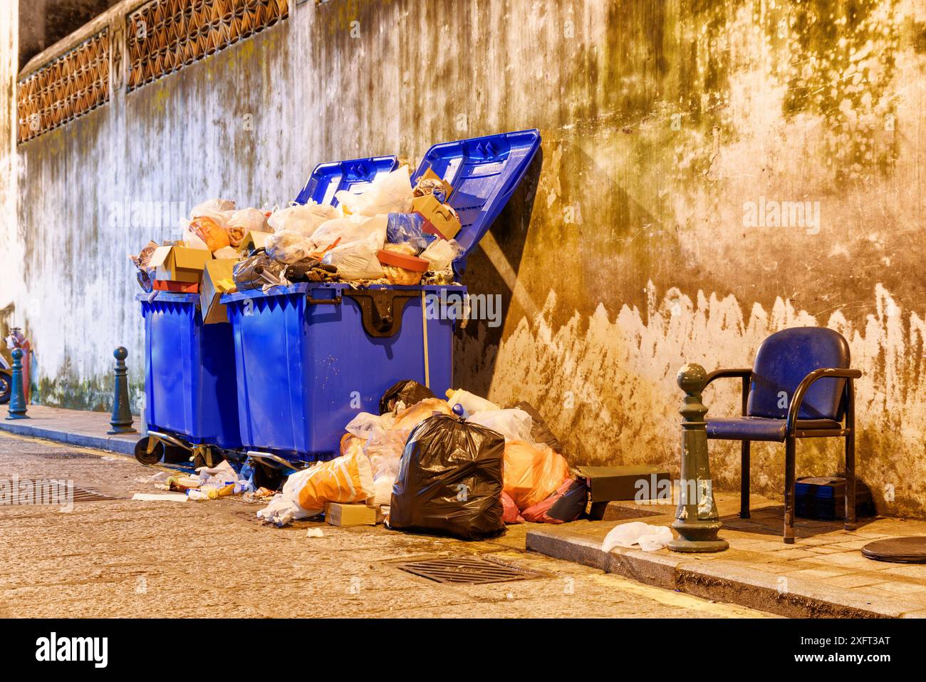 Overflowed garbage bins. View of trash cans on night street Stock Photo ...