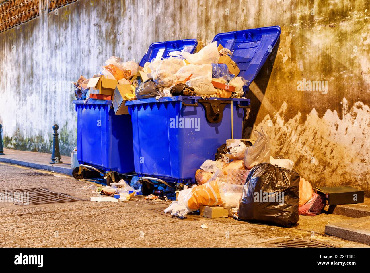 Overflowed garbage bins. View of trash cans on night street Stock Photo ...