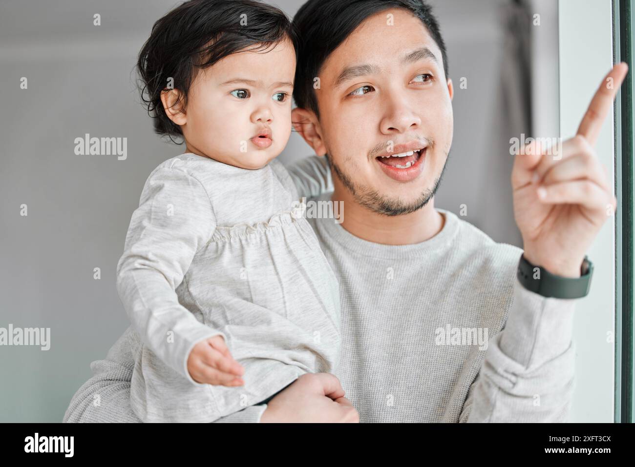 Father, baby and talking by window together, bonding and communication ...