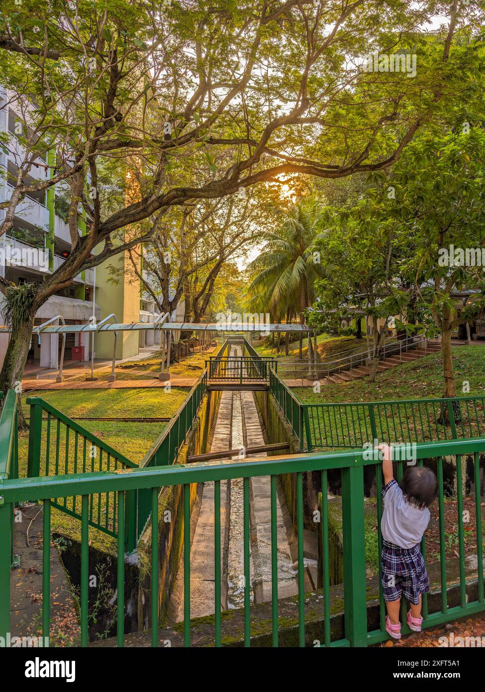 Curious girl playing by the drain at HDB estate in Singapore during ...