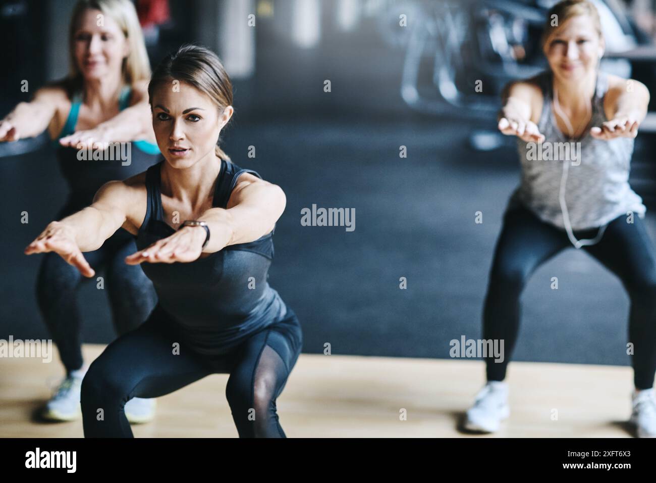 Fitness, class and women with squat in gym for muscle training, cardio ...