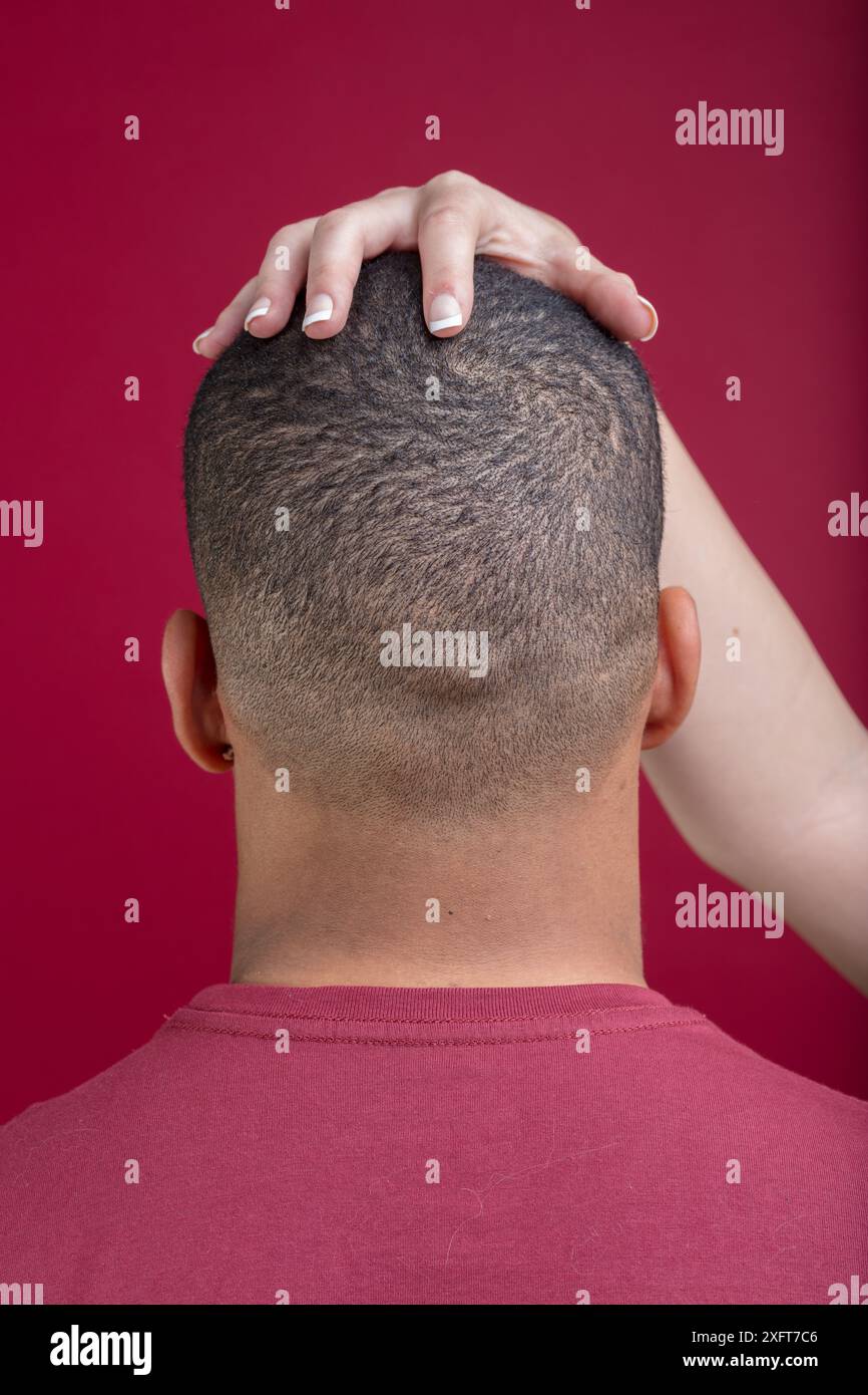 Woman hand gently touching a man's head from behind, creating a sense ...