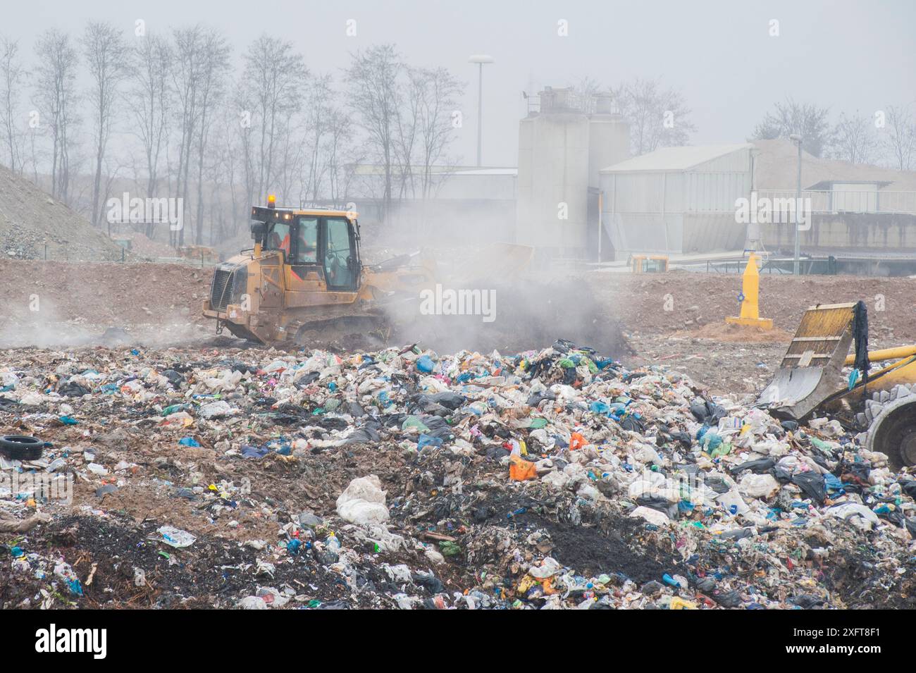 Dump municipal waste. Workers with trucks and bulldozers at work in ...