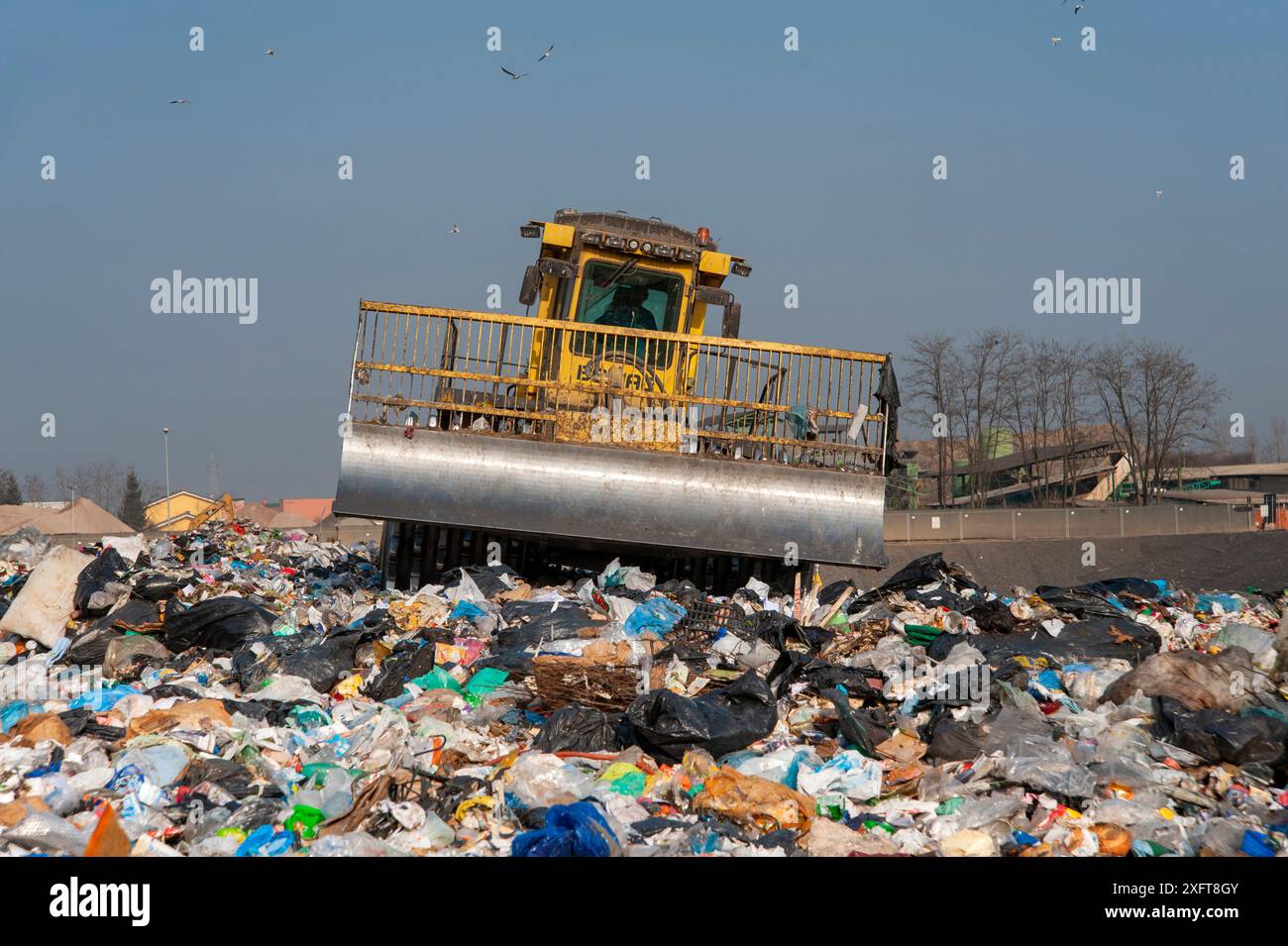 Municipal waste landfill. Workers with trucks and bulldozers at work in ...