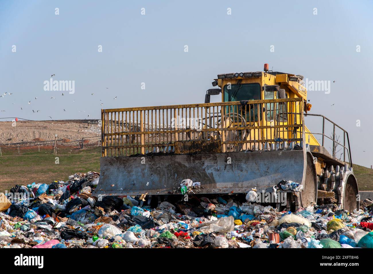 Municipal waste landfill. Workers with trucks and bulldozers at work in ...